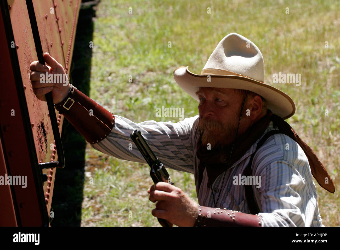 A cowboy bandit climbing onto a steam train to rob the passengers of ...