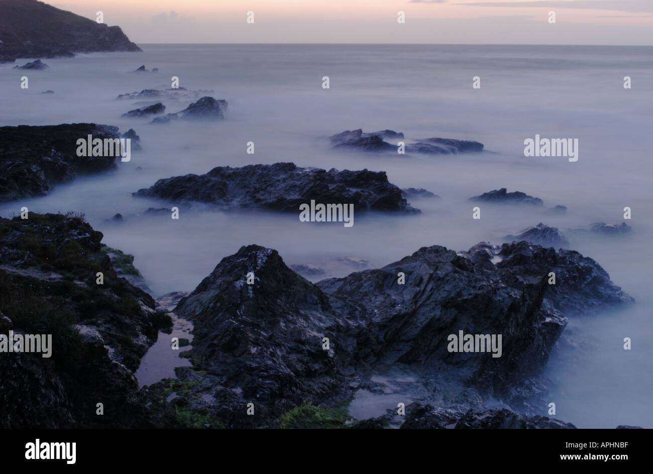 SEA WASHING ON TO ROCK AT DUSK Stock Photo - Alamy