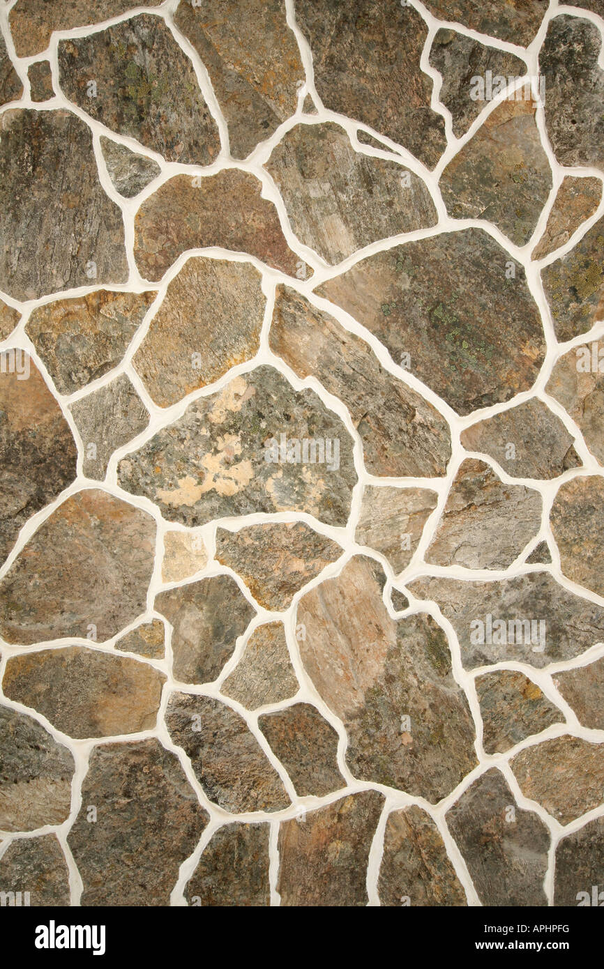 Old fashioned stone wall pattern with different sizes of stone lit with ...