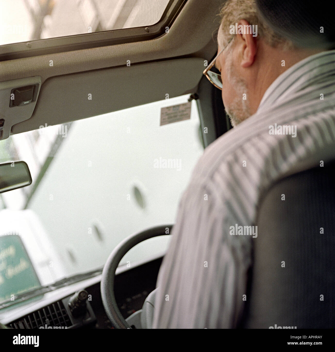 man driving car in the city viewed from the back seat Stock Photo - Alamy