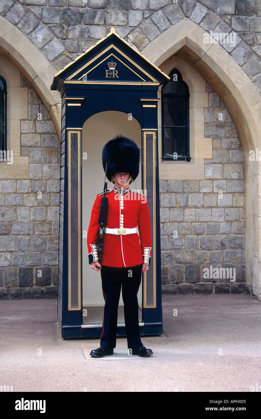 A guard in ceremonial dress of red tunic and bear skin hat stands to ...