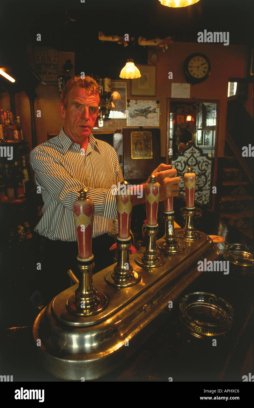 A barman standing in a pub about to pull a pint from 130 year old beer ...