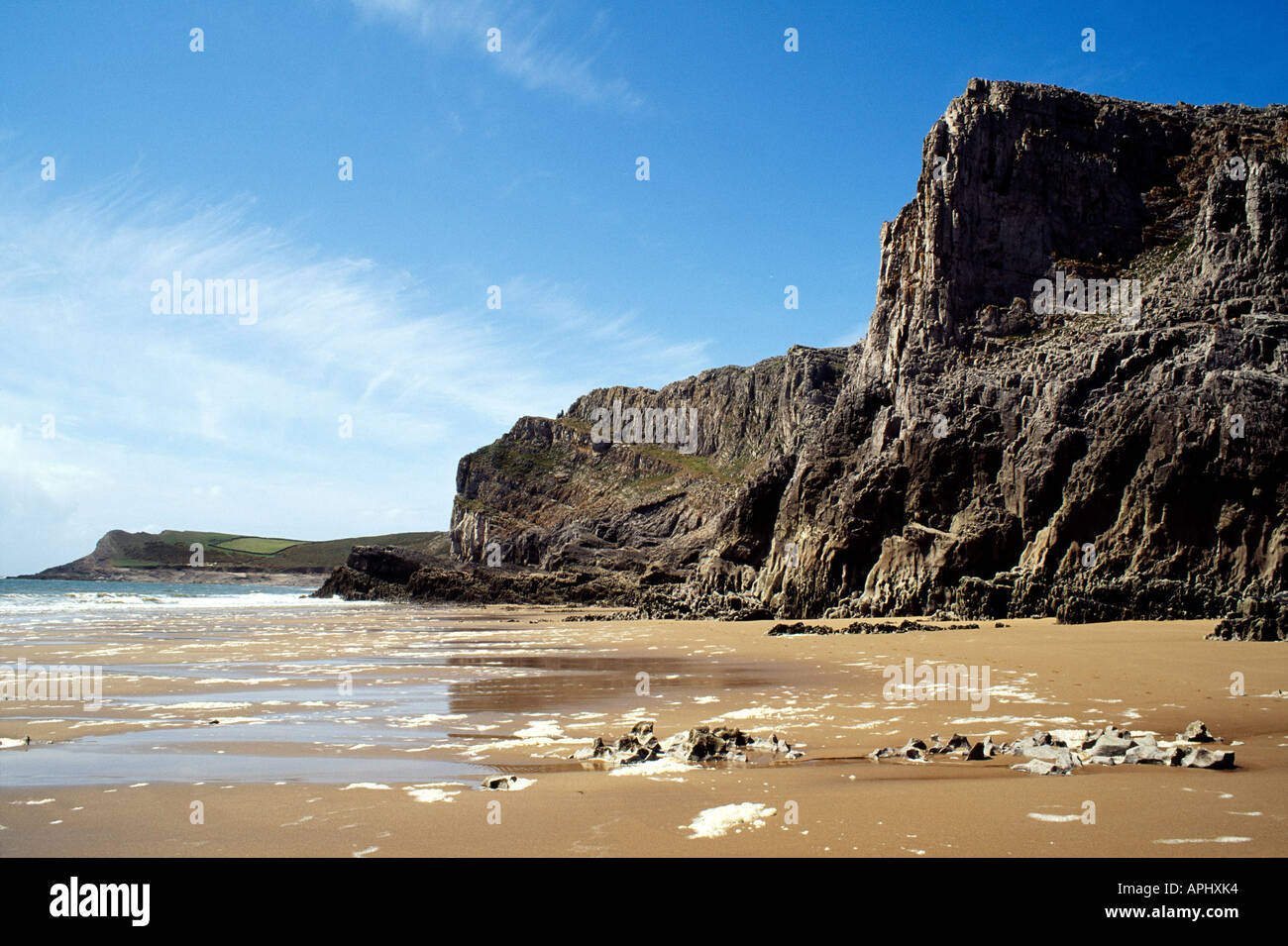 The sea at Mewslade Bay deposits spume on the sand beneath the ...