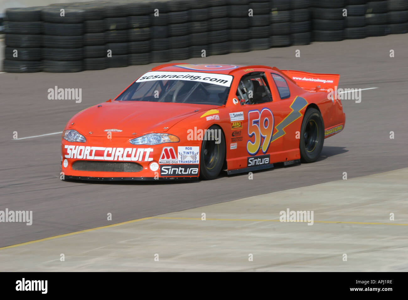 V8 Nascar type stock cars racing on a banked oval circuit Stock Photo ...