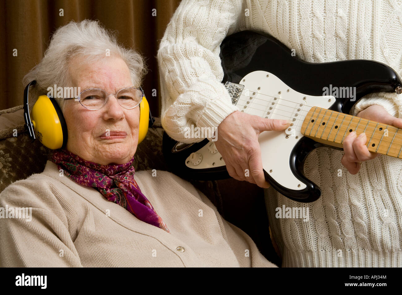 Elderly lady wearing ear ^defenders and looking smug Stock Photo - Alamy