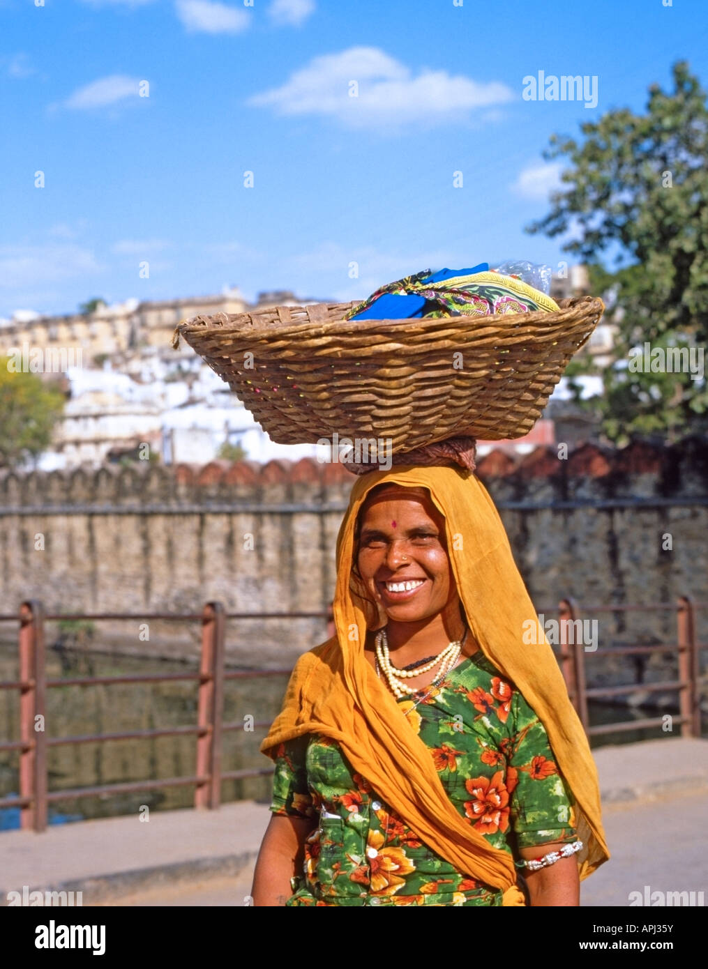 Indian woman with basket on her head Stock Photo - Alamy