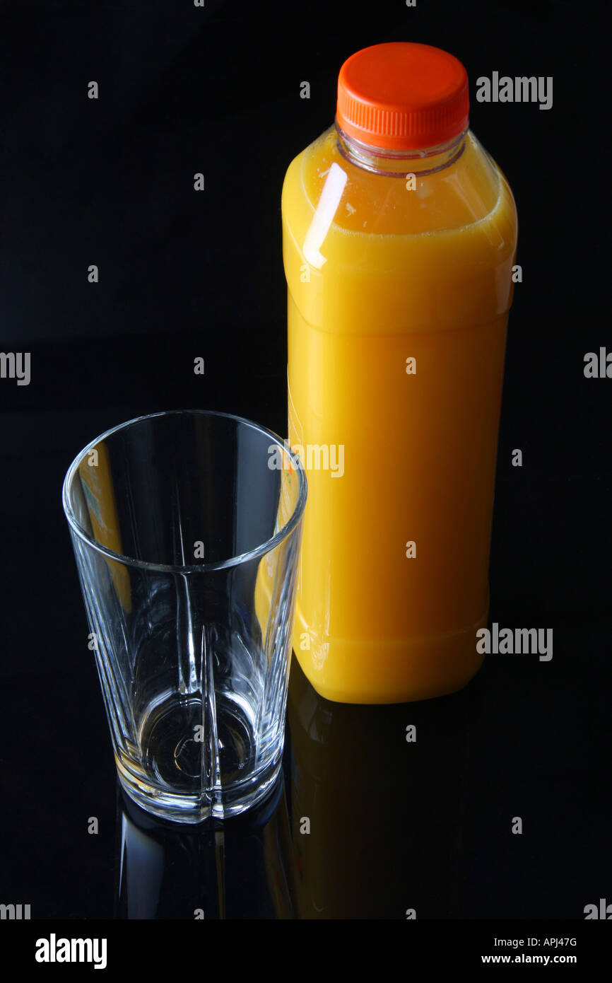fresh orange juice in a bottle standing next to a empty glass shot on ...