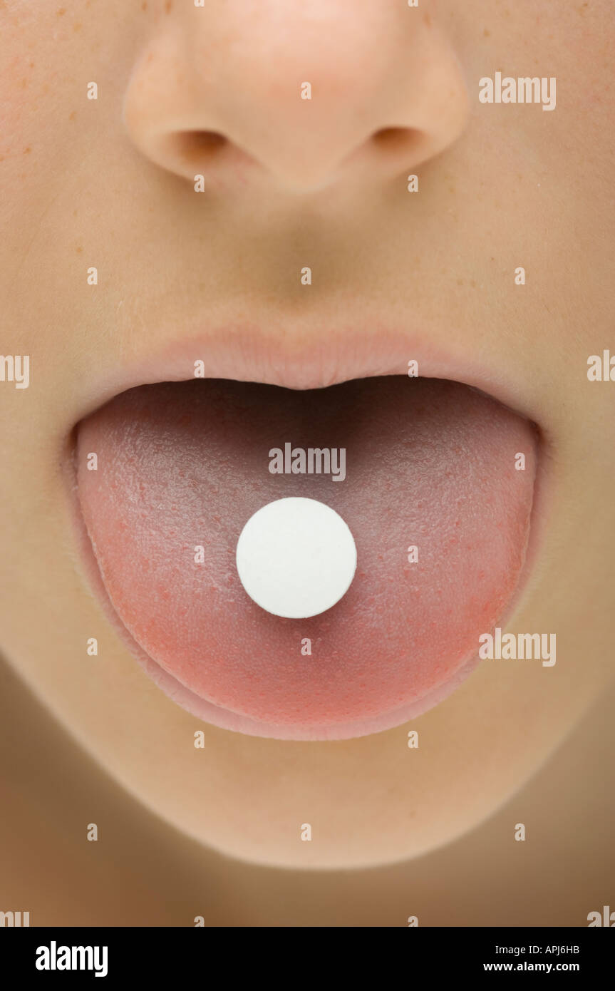 extreme close up of white pill centered on tongue about to be eaten ...