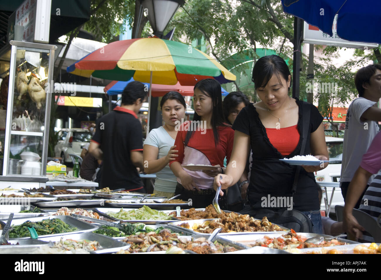 Women helping themselves at an outdoor restaurant, Bukit Bintang Stock ...