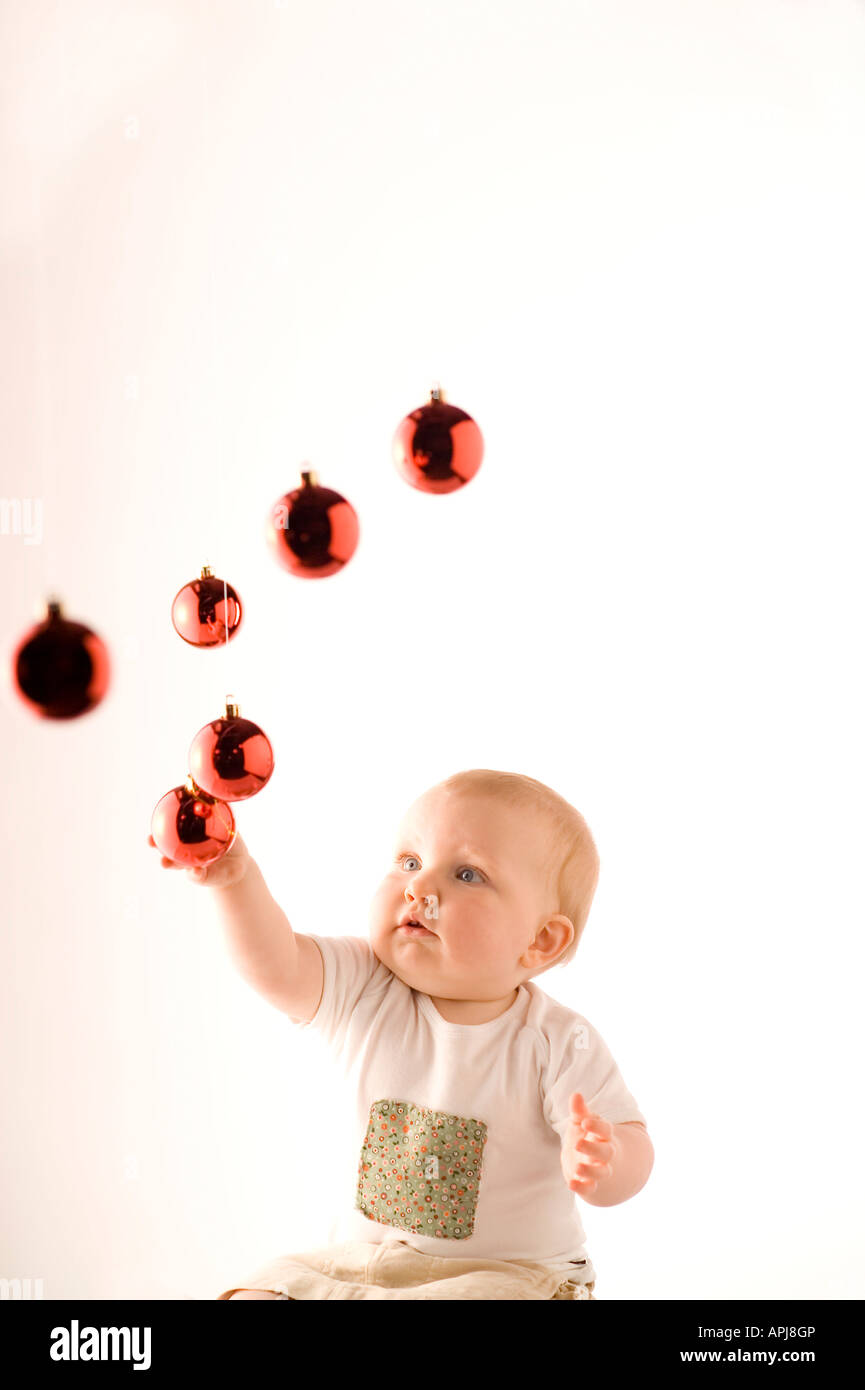 Baby reaching for the overhead baubles Stock Photo - Alamy