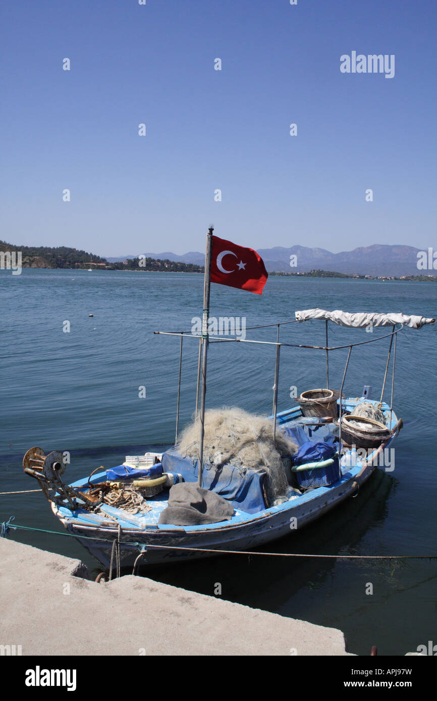 A turkish fishing boat docked at Fethiye harbour with a turkish flag ...