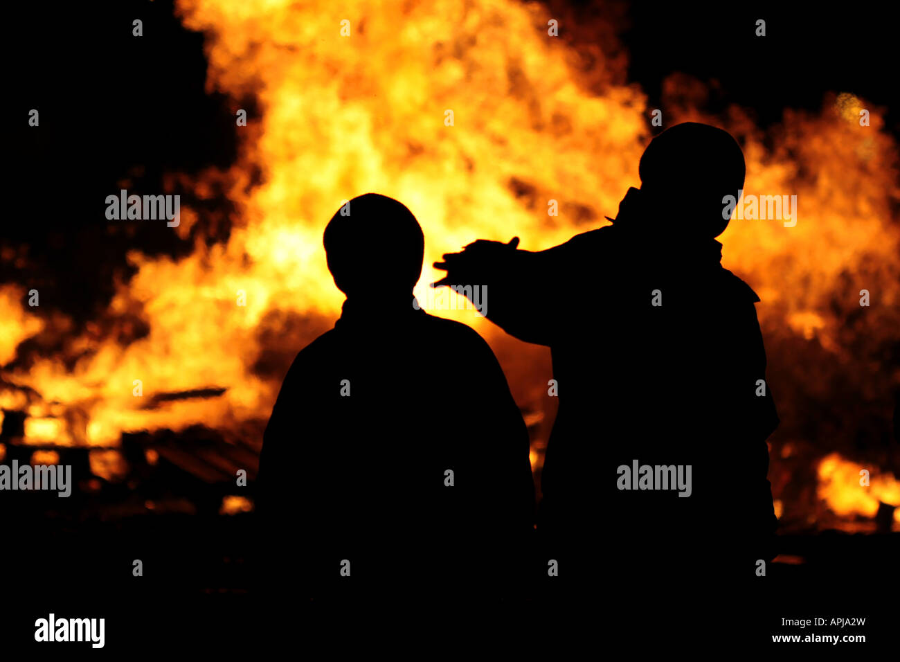 silhouettes set against fire pointing towards it Stock Photo - Alamy