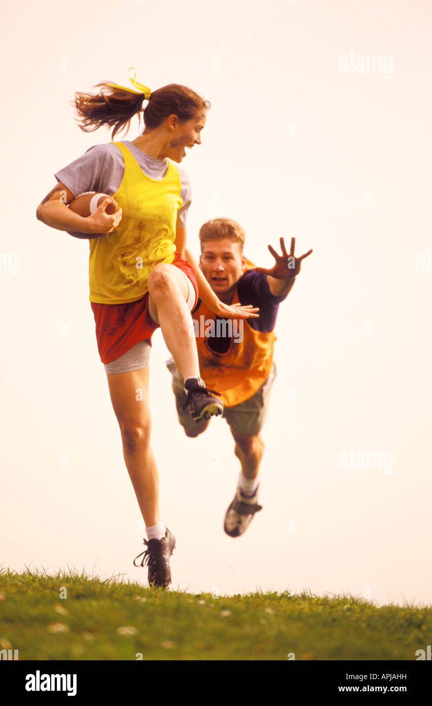 A young woman straight arms her male opponent as she leaps away from ...