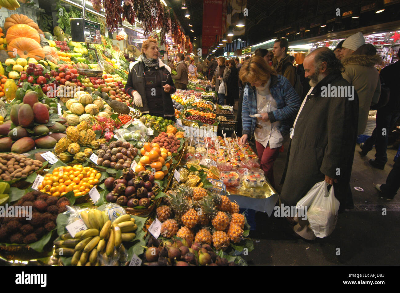 People buying fruits in a stand of the Boqueria Market or Mercado de la ...