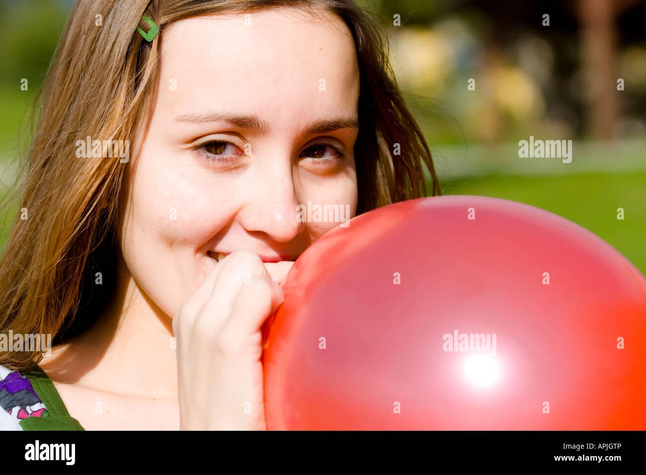Young woman inflating red balloon Stock Photo - Alamy