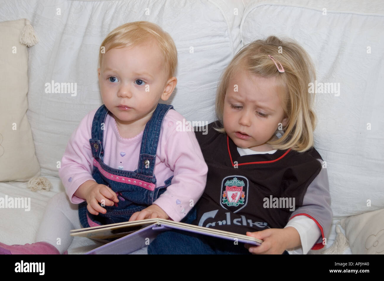 Toddler and baby reading Stock Photo - Alamy