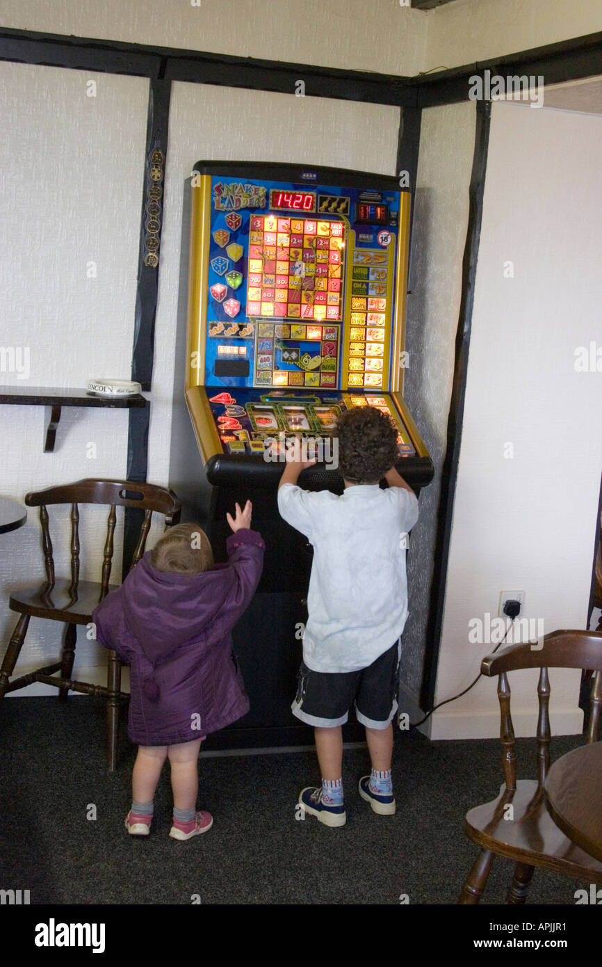 Children looking at a pub fruit machine Stock Photo - Alamy