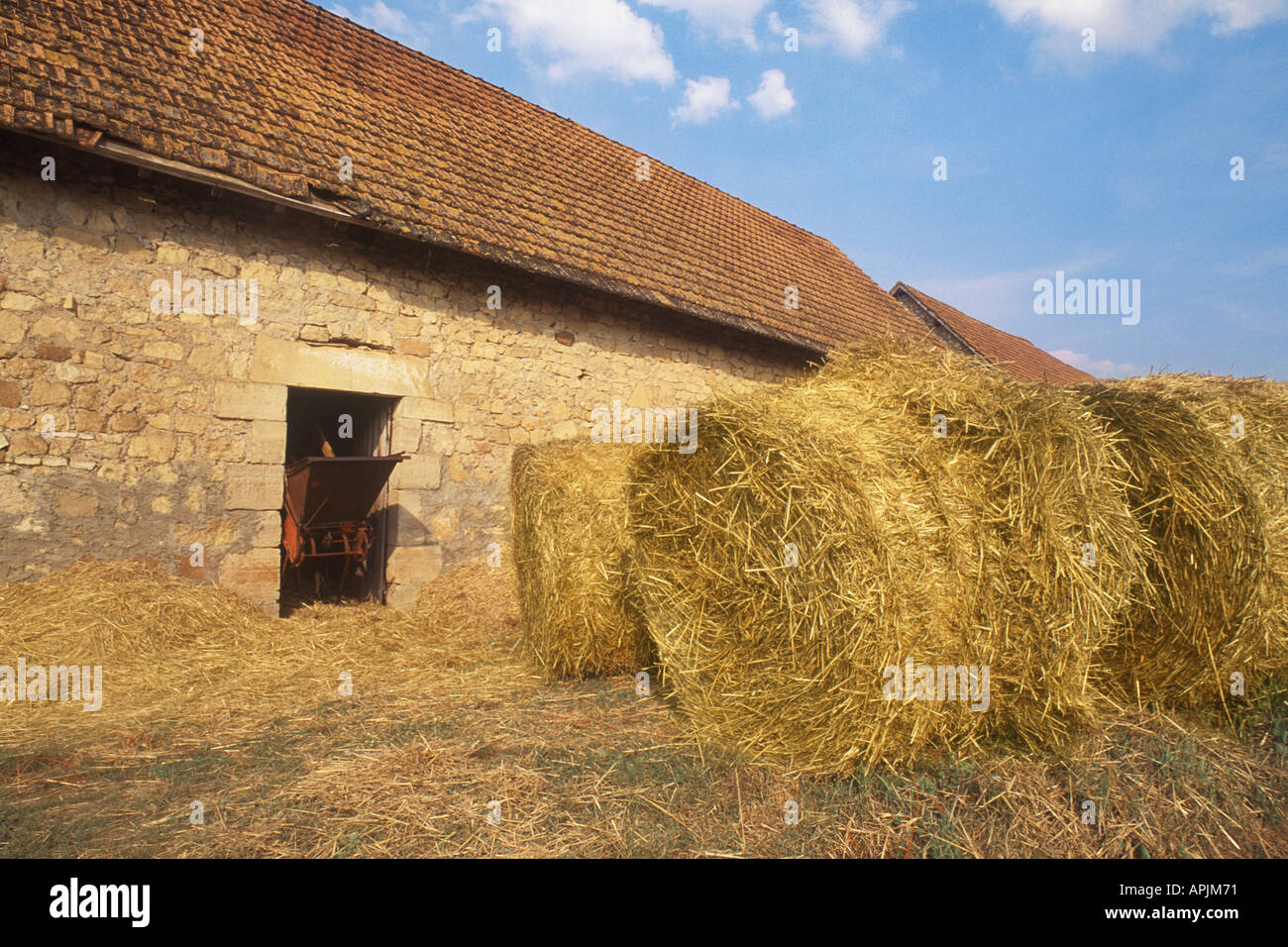 France. Hay bales. Stone barn with a tile roof on the grounds of the ...
