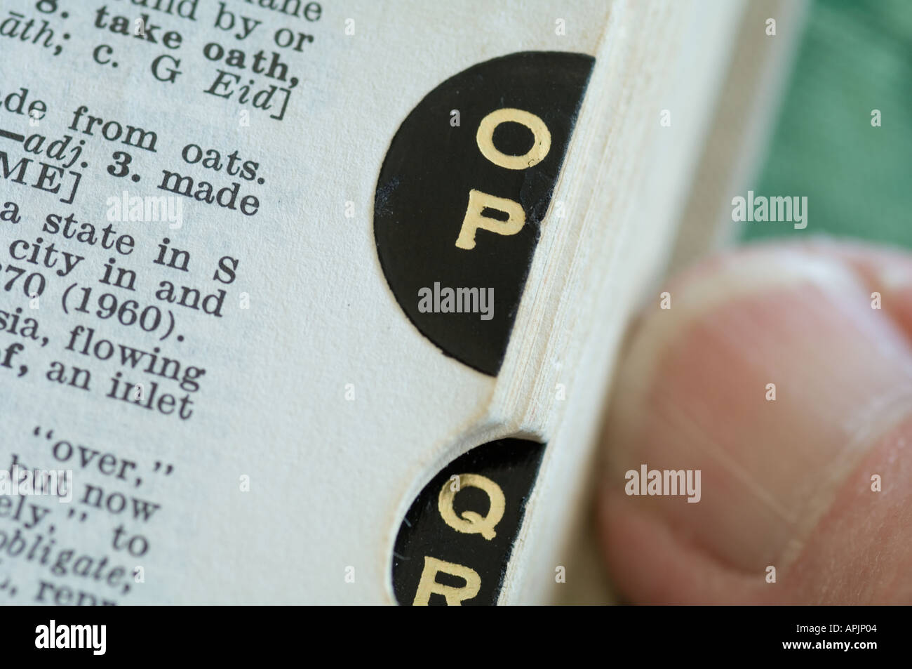 Closeup of a hand selecting a page in a dictionary Stock Photo - Alamy