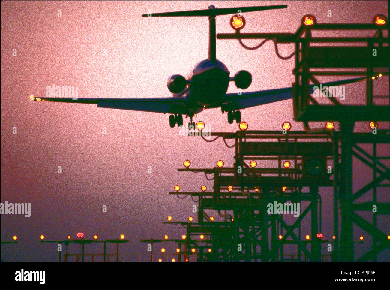 commercial jet landing with lights at dusk Stock Photo - Alamy