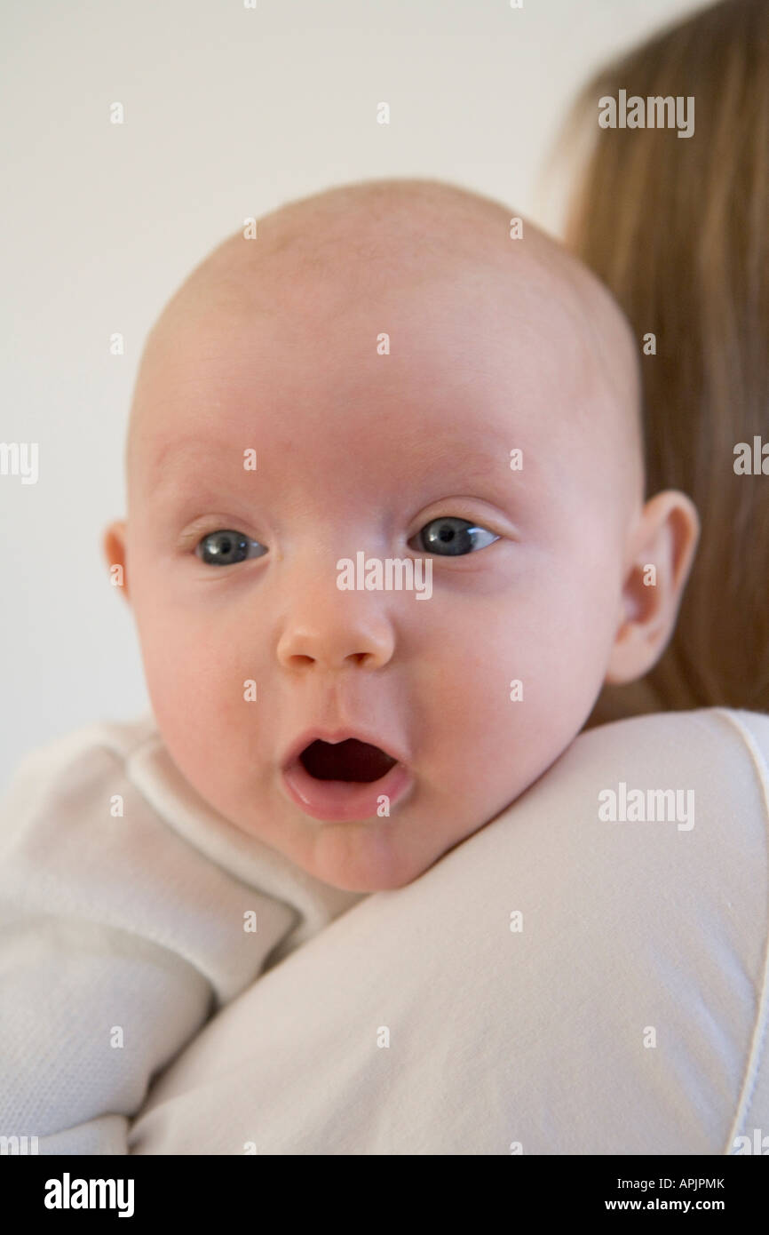 Baby looking over mothers shoulder Stock Photo - Alamy