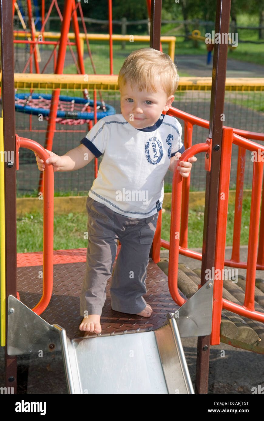 toddler sixteen months boy top of small slide in playground Stock Photo ...
