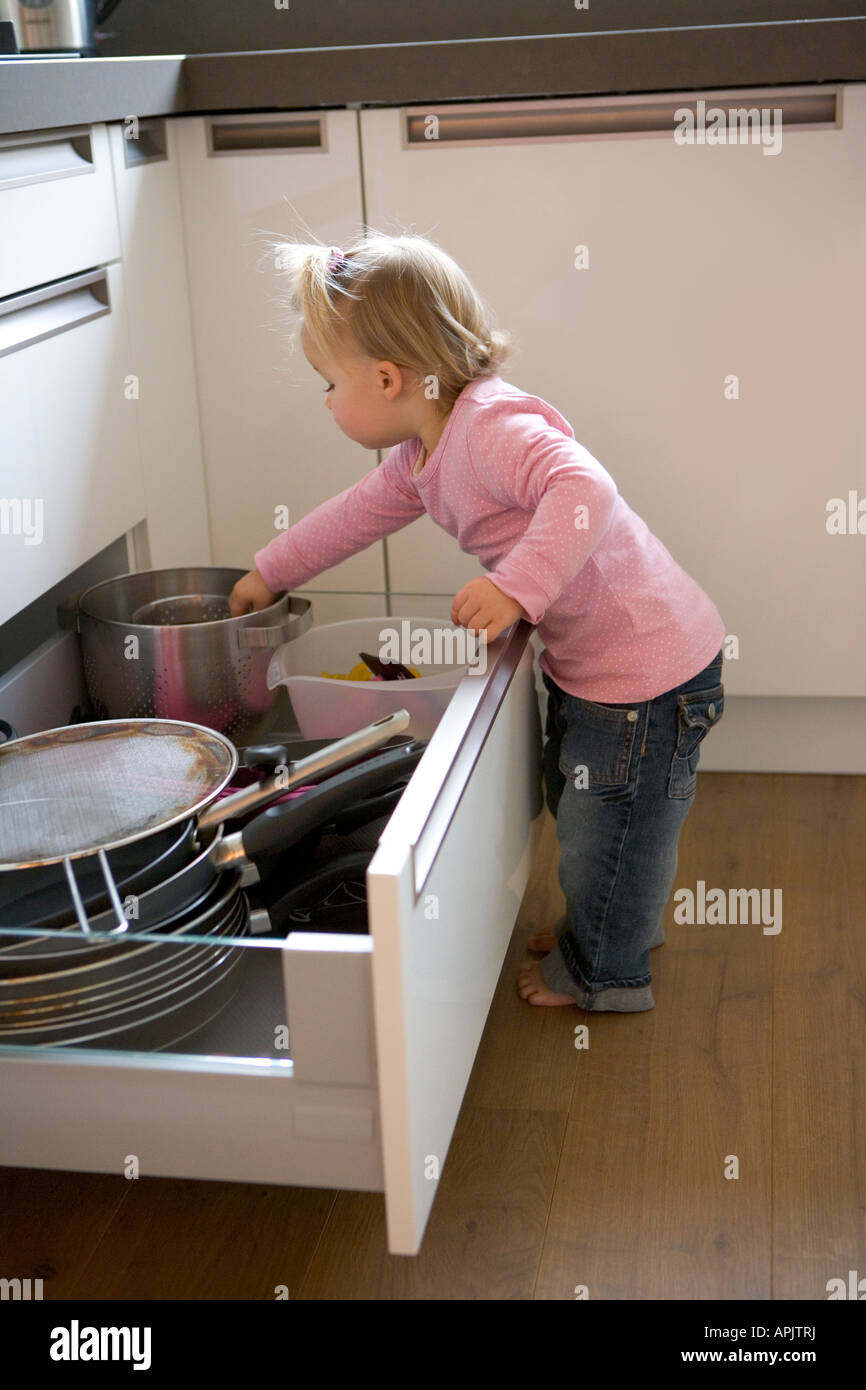 Little girl opens a kithchen drawer Stock Photo - Alamy