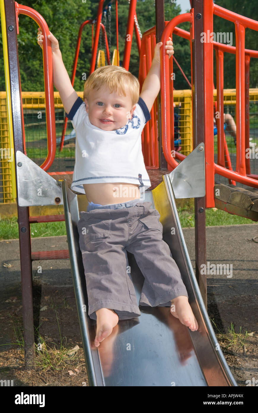toddler sixteen months boy top of small slide in playground Stock Photo ...