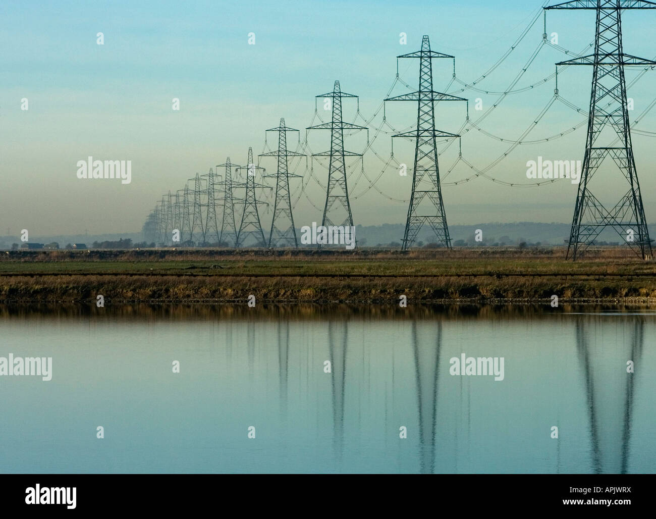 Electricity pylons are reflected in water on Romney Marsh in Kent ...