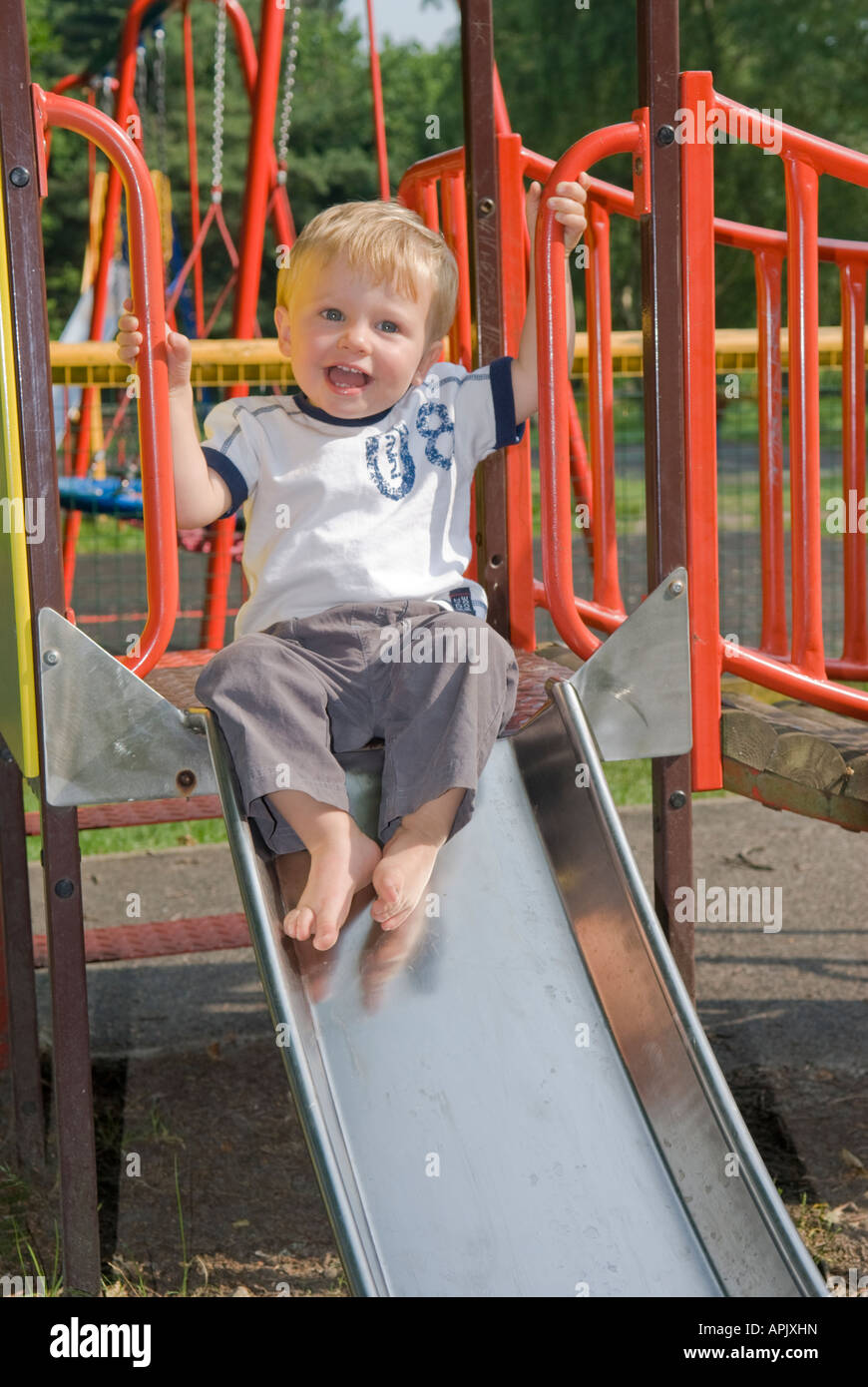 toddler sixteen months boy top of small slide in playground Stock Photo ...