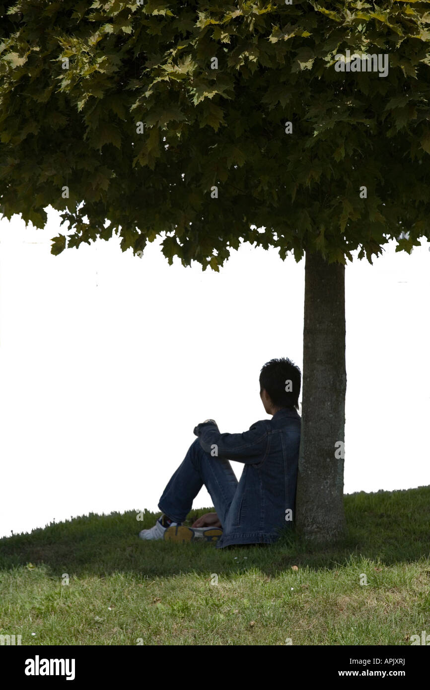 Boy Sitting Against Tree Stock Photos & Boy Sitting Against Tree Stock ...