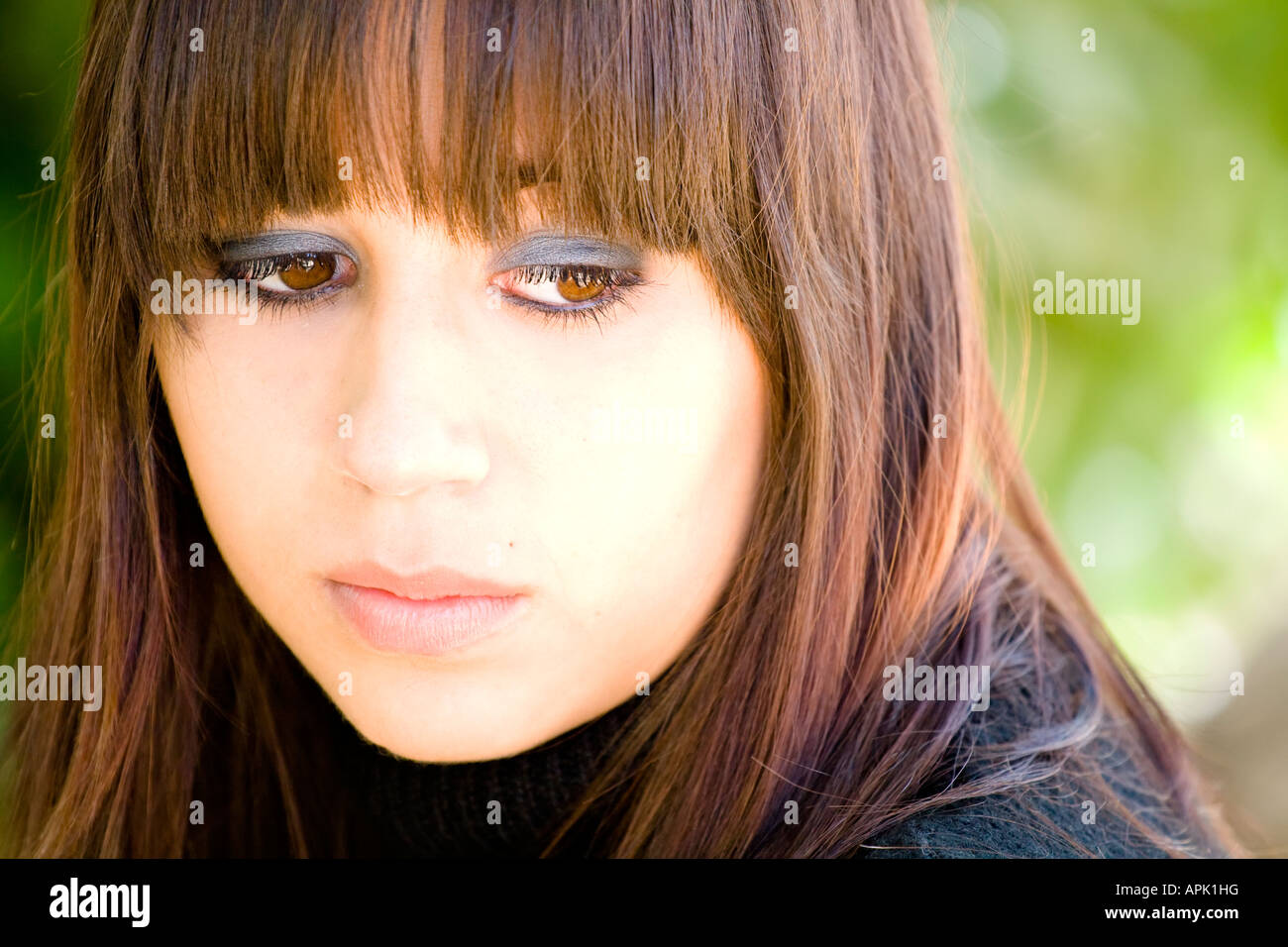 Sad girl portrait in green background Stock Photo - Alamy