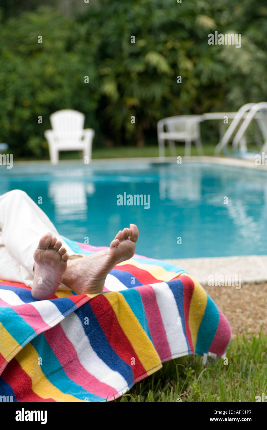 woman's feet resting on lounge by pool Stock Photo - Alamy