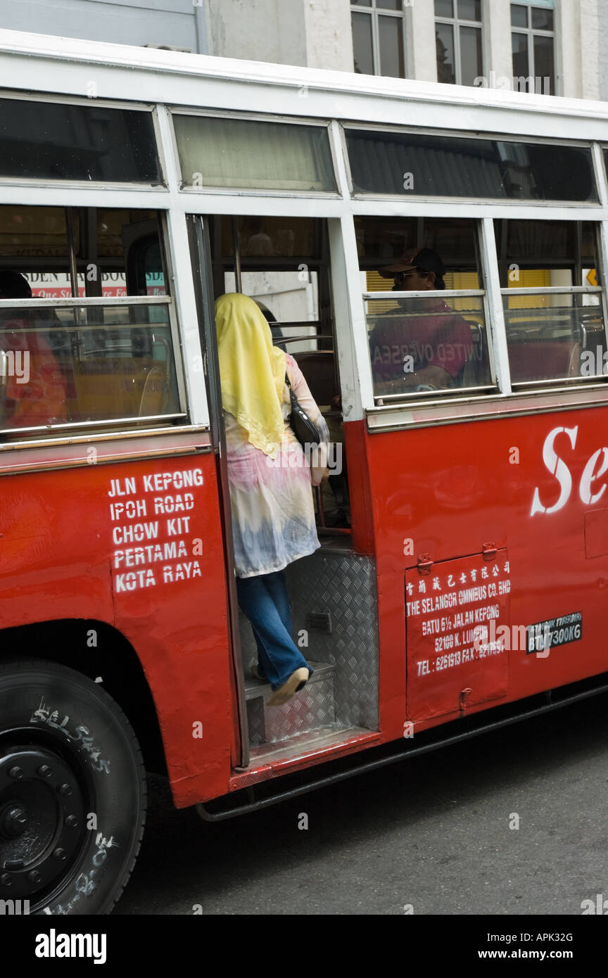 A colourfully-dressed muslim lady in hijab boards a bus in central ...
