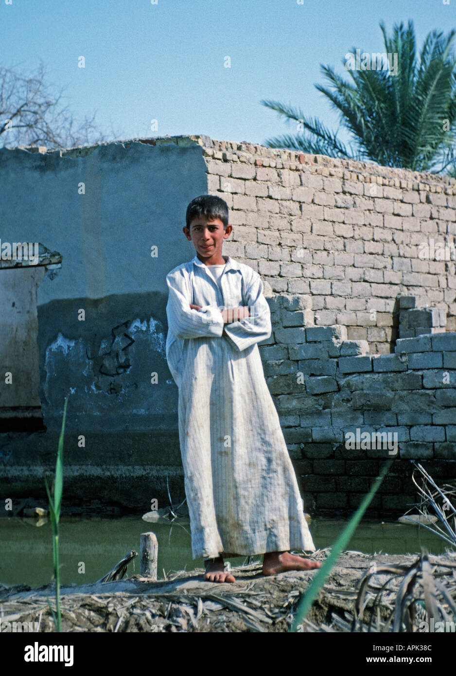 IRAQ NASIRIYA Young Iraqi boy in traditional dress standing in front of ...