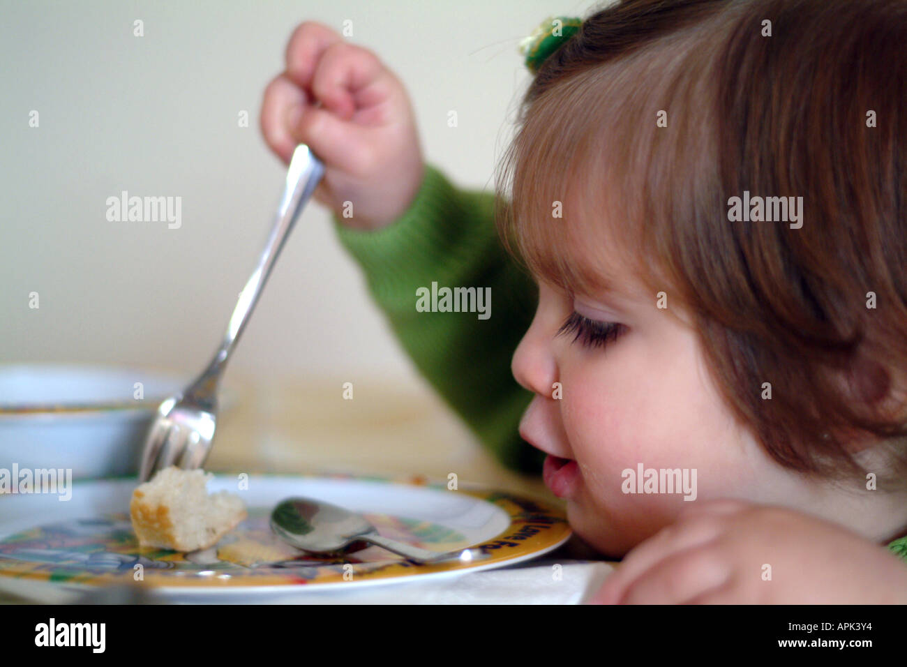 Little girl learning to use cutlery Stock Photo - Alamy