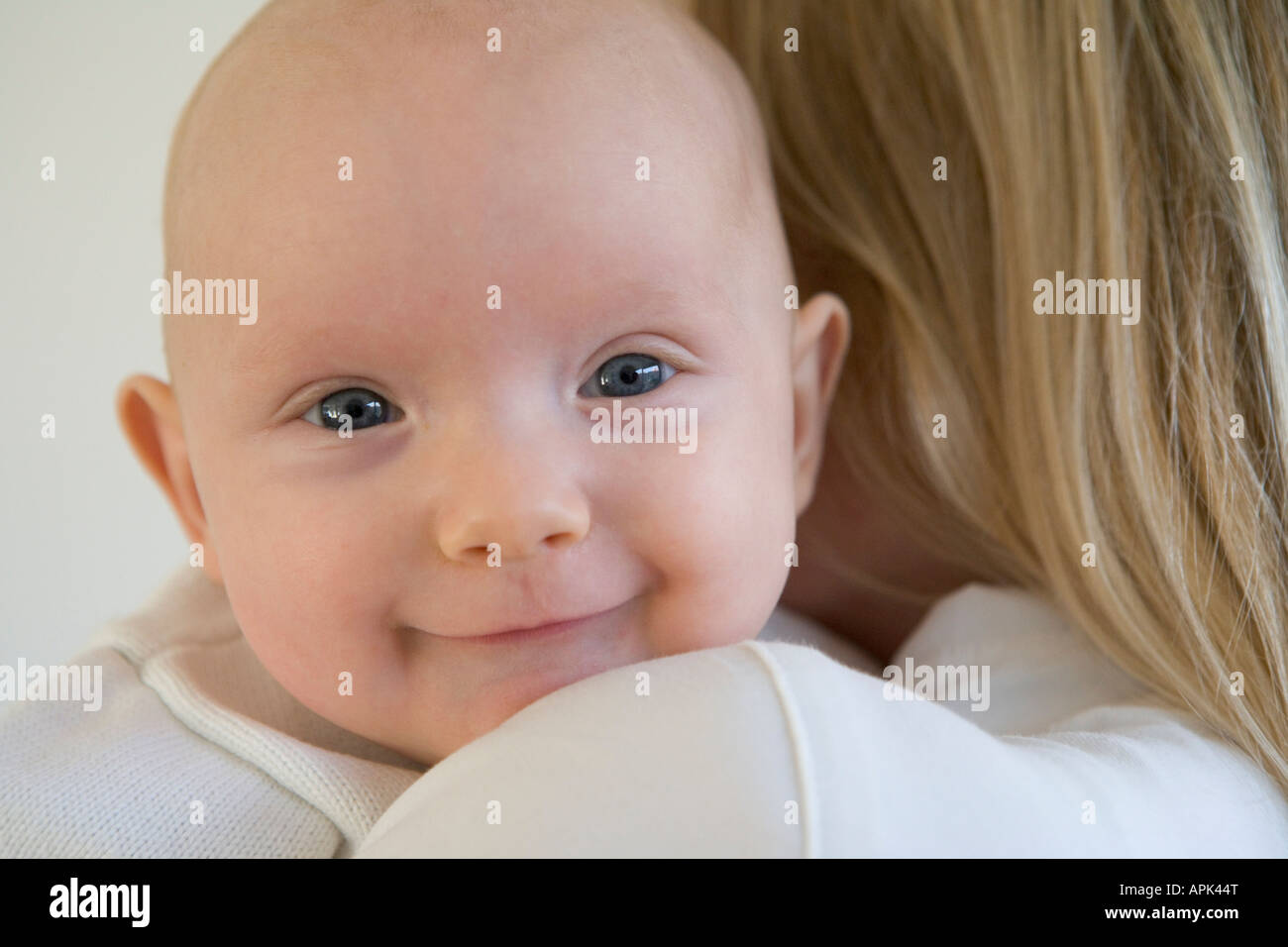 Baby looking over mothers shoulder Stock Photo - Alamy