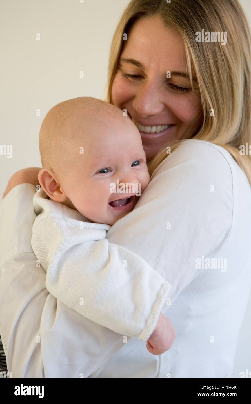Baby looking over mothers shoulder Stock Photo - Alamy