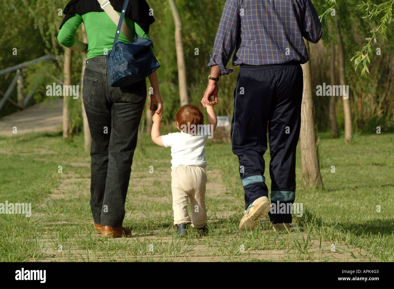 Mother helping baby daughter walk hi-res stock photography and images ...