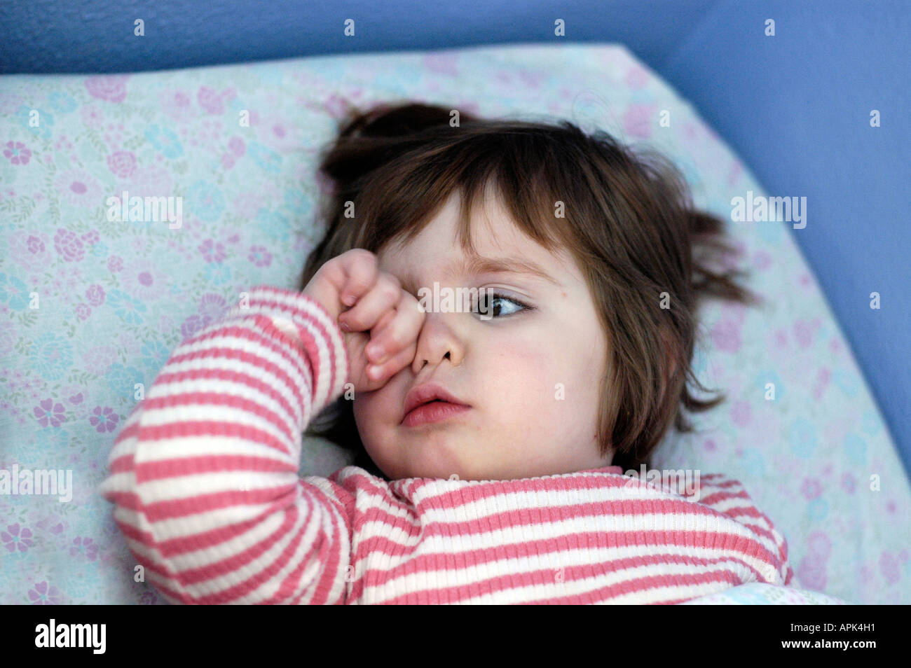 Portrait of a sleepy little girl on a bed Stock Photo - Alamy