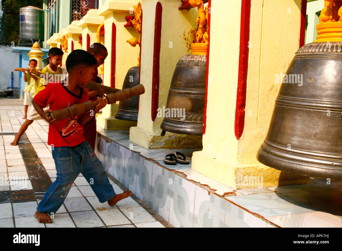young children ringing bells in a mandlay temple Stock Photo - Alamy