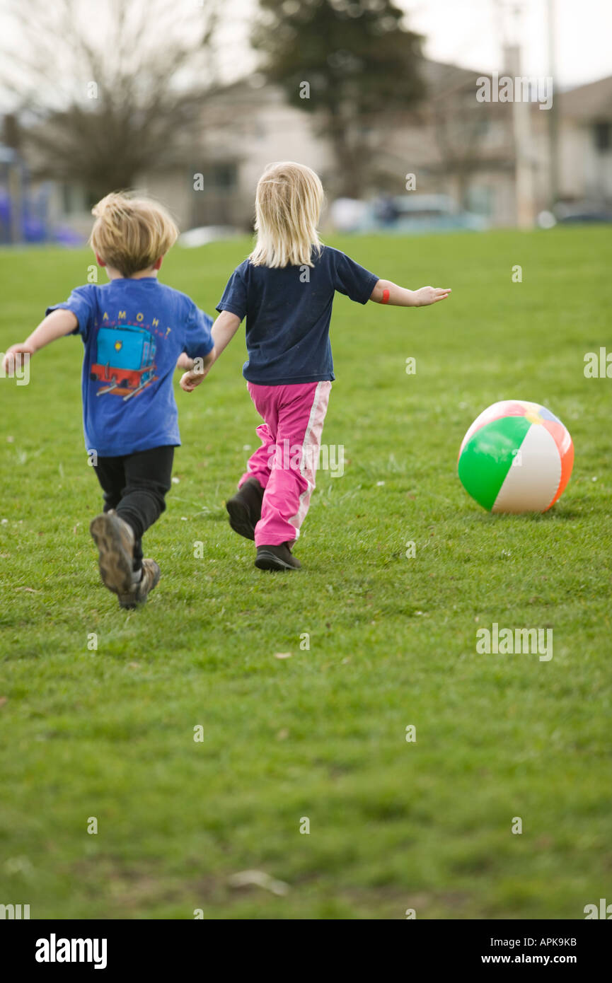 3 Year Old Boy and 4 Year Old Girl Playing With a Beachball at a Stock ...