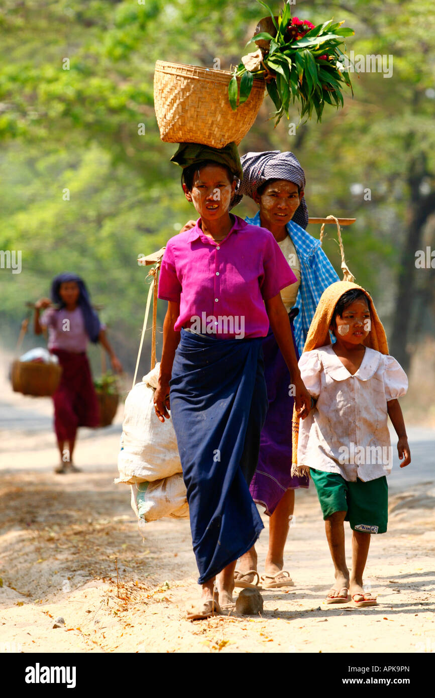 traditional burmese ladies walking down a dusty road - lead lady with ...