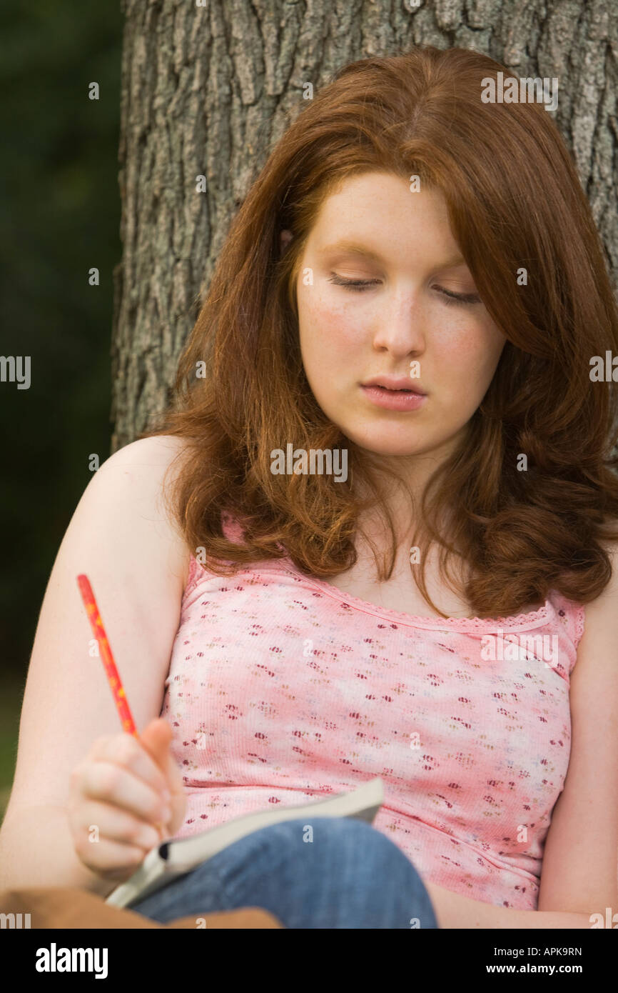 ILLINOIS Riverwoods Red haired teenage girl studying writing in ...