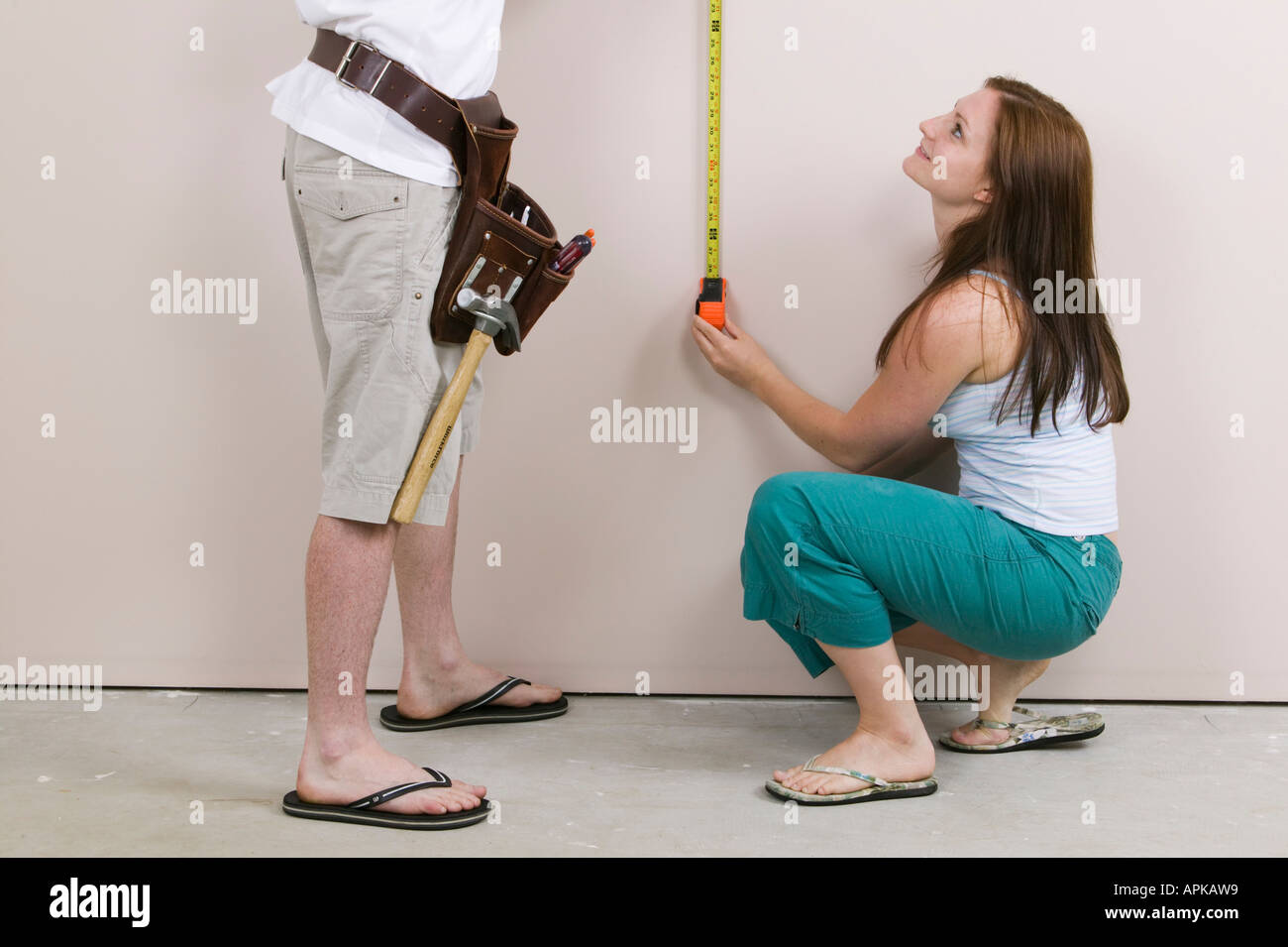 Couple Measuring a Wall Stock Photo - Alamy