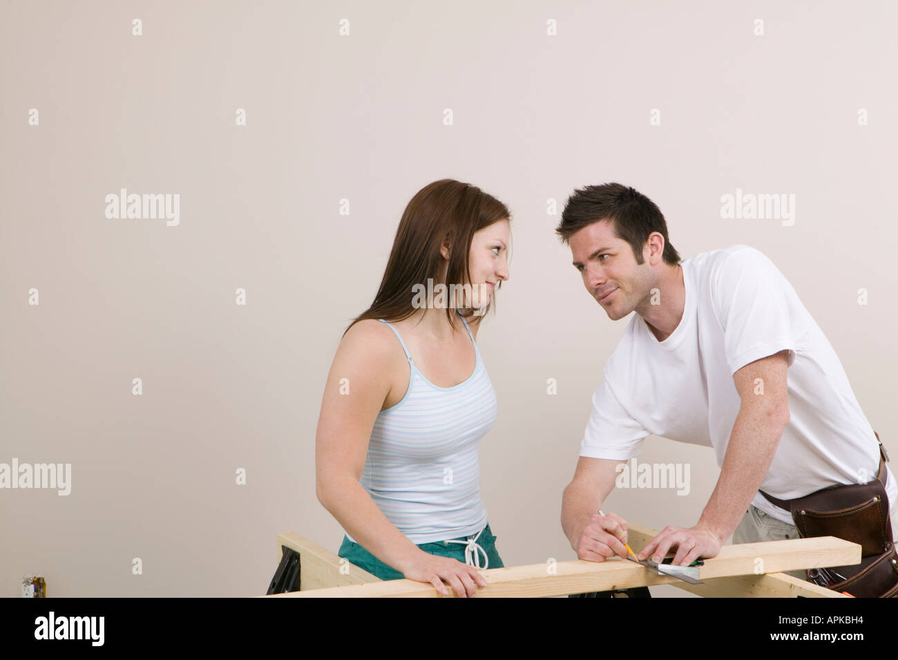 Couple Measuring a Board Stock Photo - Alamy