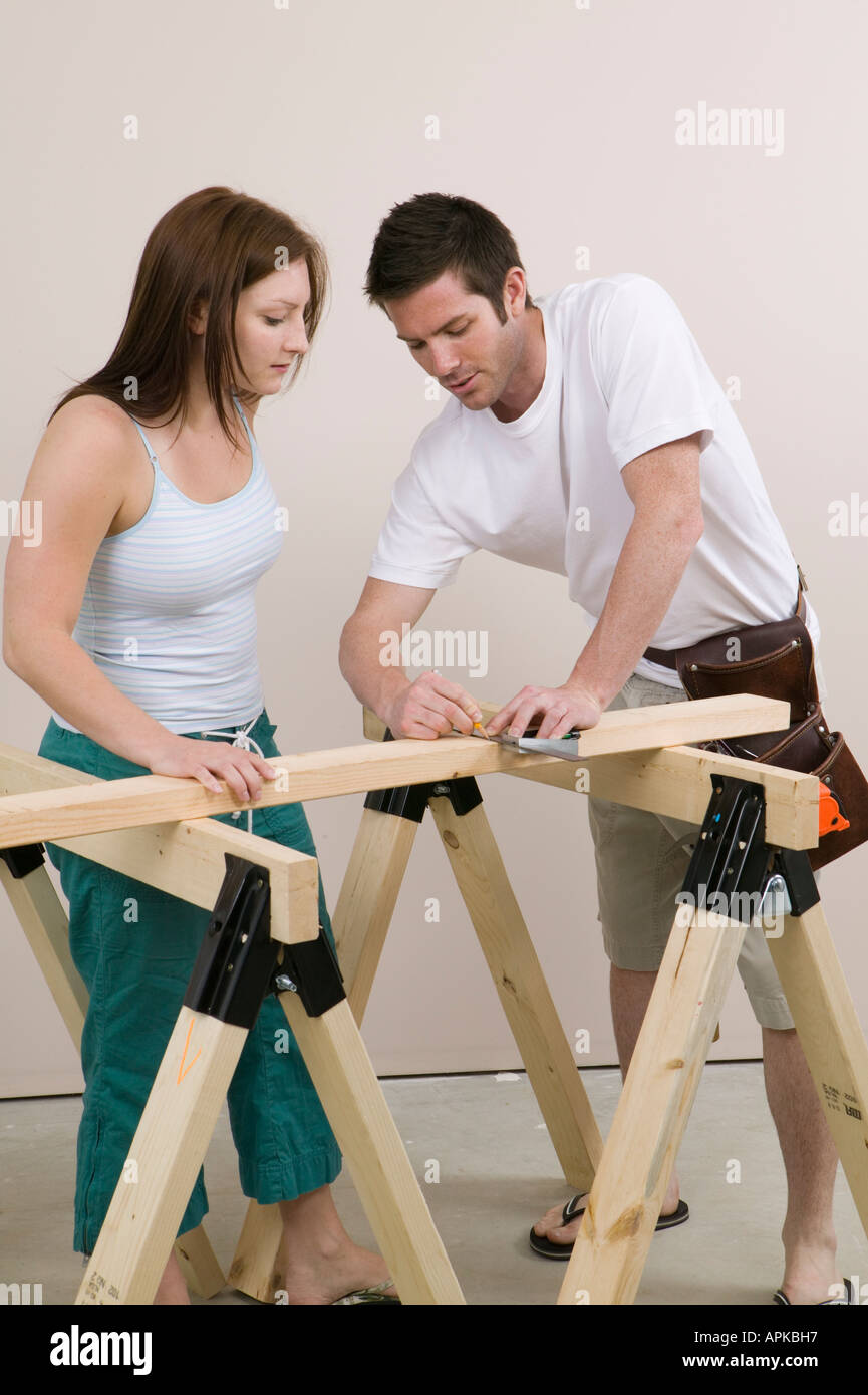 Couple Measuring a Board Stock Photo - Alamy