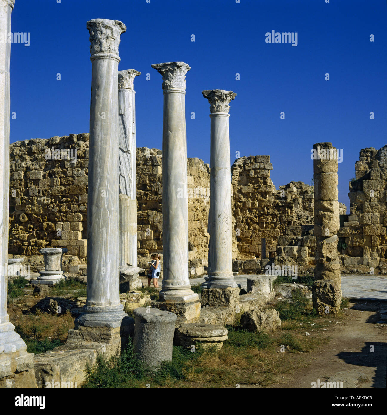 A couple standing looking at four lovely white stone columns in the ...