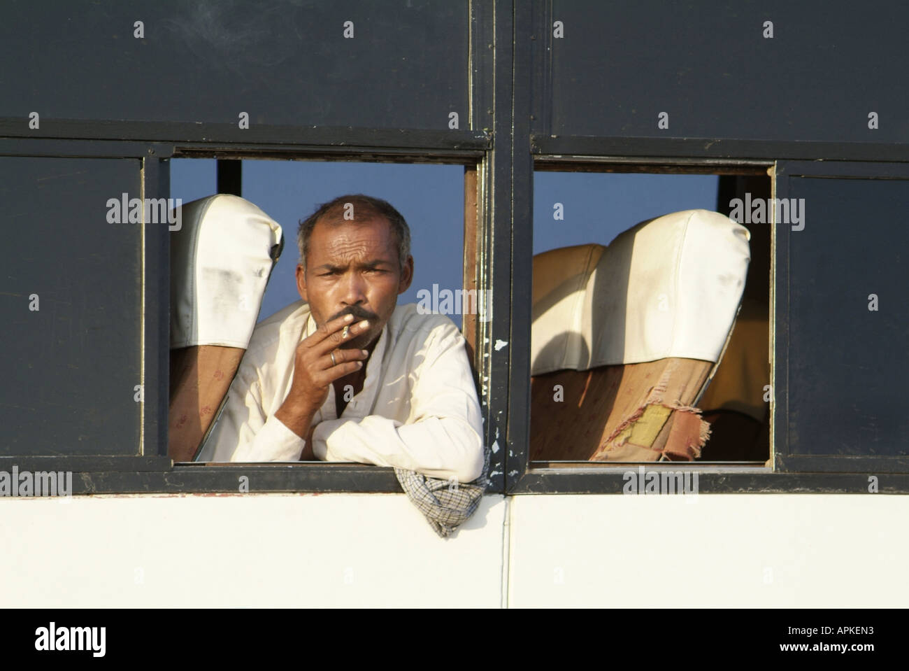 Man smoking a cigarette out a bus window, India Stock Photo - Alamy