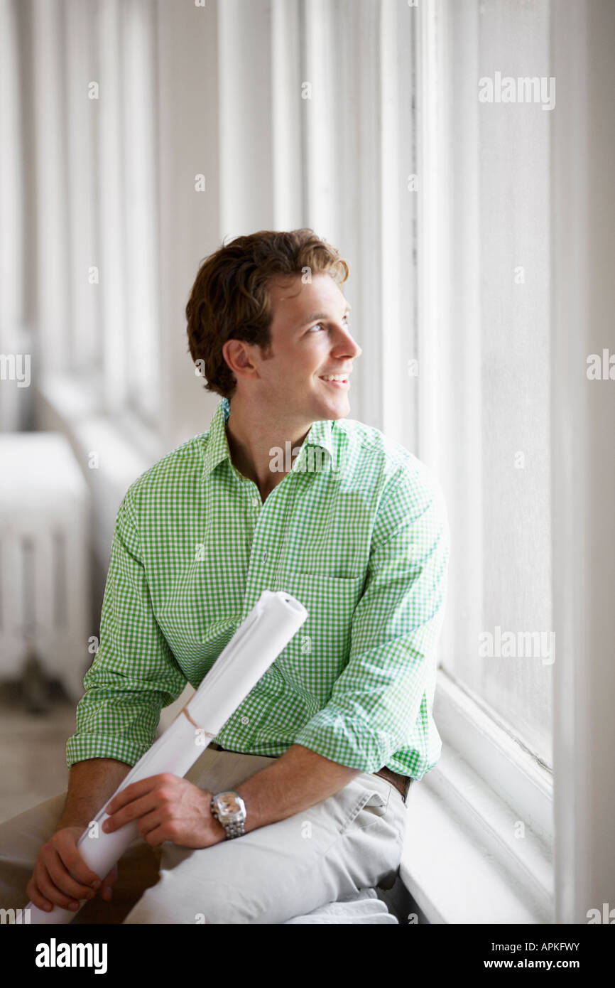Man sitting and looking through window Stock Photo - Alamy